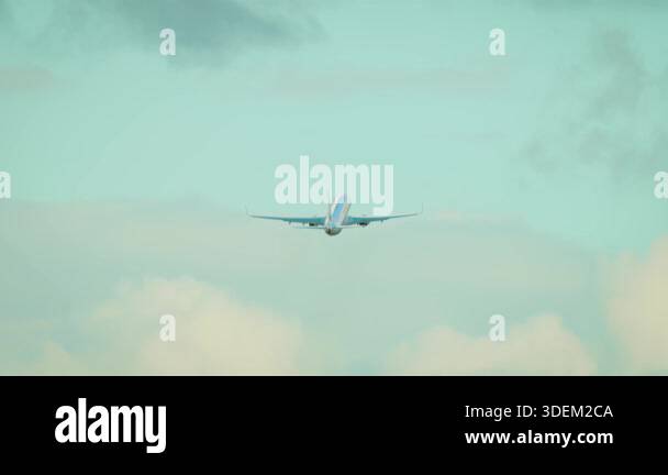Jetliner climbing into bright sky above soft clouds. Passenger aircraft ...