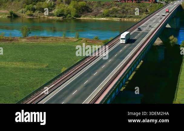 Semi truck driving on busy bridge over river with other vehicles in ...
