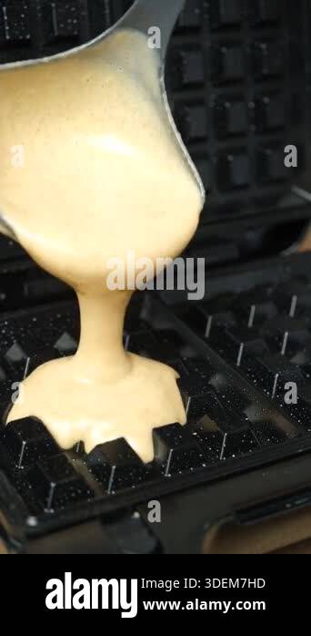 Pouring Fresh Waffle Batter with a Ladle into a Black Electric Waffle ...