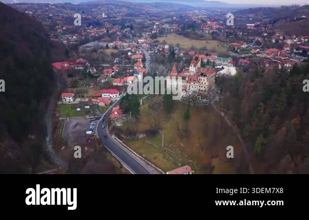 Aerial drone footage of Bran Castle and the surrounding village, roads ...