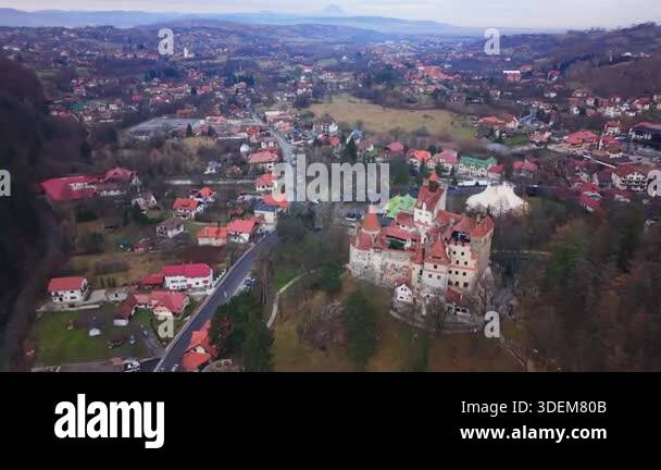 Aerial drone footage of Bran Castle overlooking the forested hills near ...