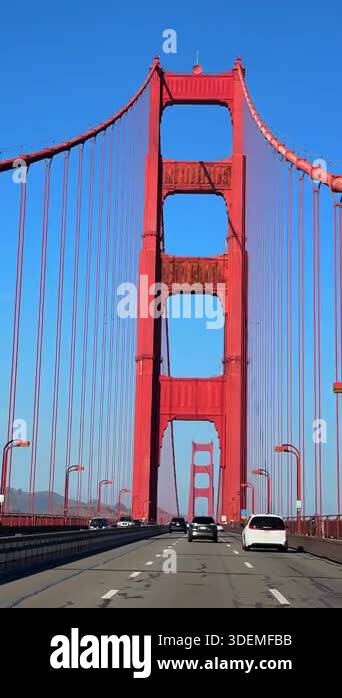 Driving across Golden Gate Bridge in San Francisco with red towers and ...