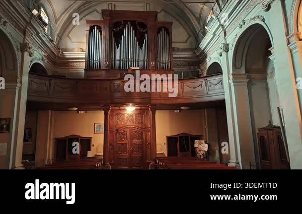 Wooden church organ with pipes under arches in catholic church interior ...