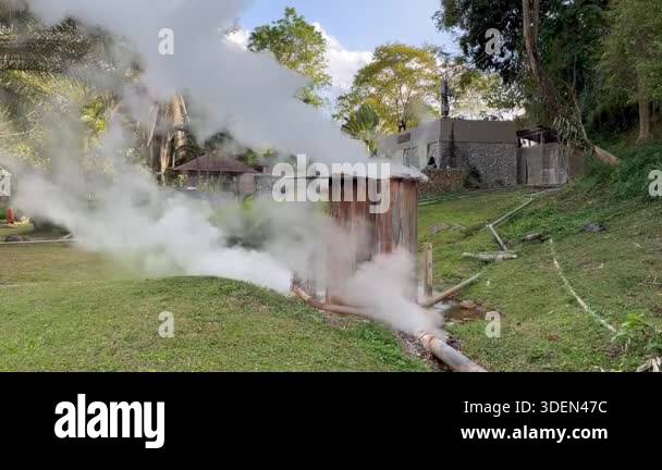 Geothermal steam vent releasing hot vapor from underground in rural ...
