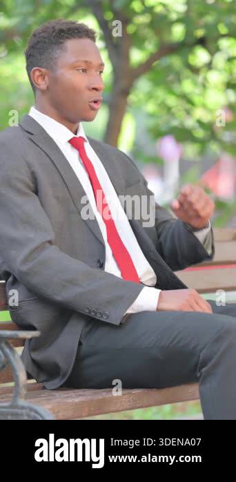 African Businessman Checking Time while Waiting Outdoor on Bench Stock ...