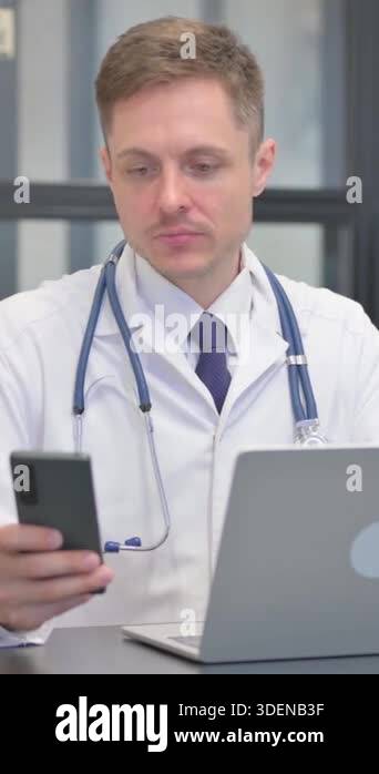 Vertical video, Male Doctor Working on Multiple Digital Devices Stock ...