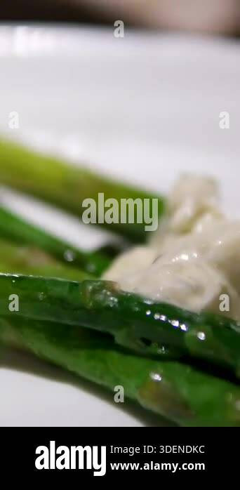Appetizing organic asparagus fried in butter on a blue plate close-up ...