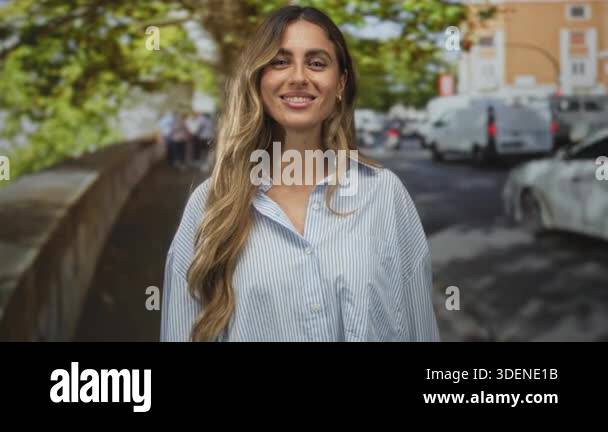 Young blonde lady face smiling with flowing hair in striped blouse on ...