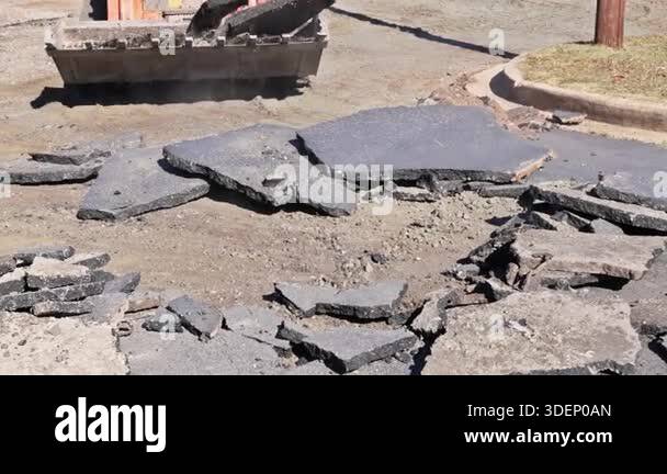 Heavy machinery is breaking up old pavement at construction site while ...