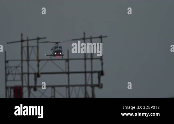 Military helicopter flying in rainy weather near airport navigation ...
