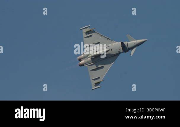 Military delta wing fighter jet flying overhead armed with missiles ...
