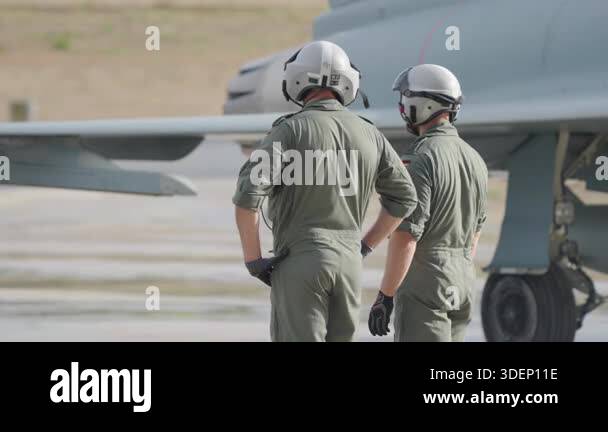 Ground crew member kneeling beside aircraft landing gear inspecting ...