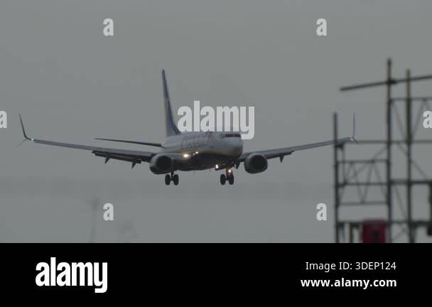 Twin engine passenger jet with landing gear deployed and lights on ...
