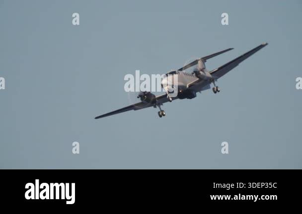 Twin engine high wing turboprop aircraft approaching with landing gear ...