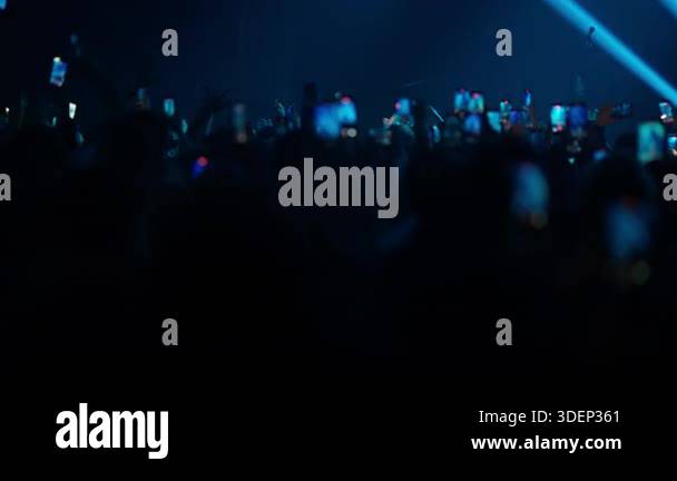 Large concert crowd holding smartphones and recording live performance ...