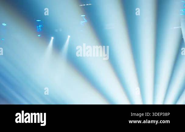 Intense blue stage lights projecting wide beams across dark venue ...
