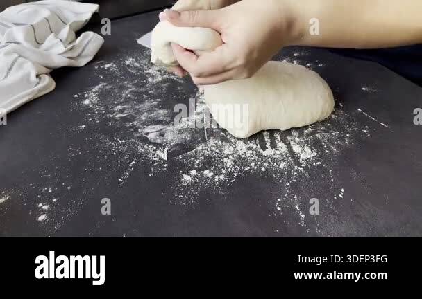 Female hands cutting and forming balls of fresh yeast dough on floured ...