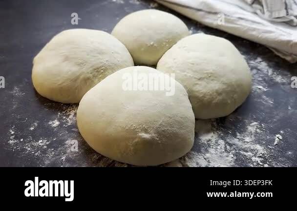Female hand checking fresh yeast dough on floured kitchen table, rest ...