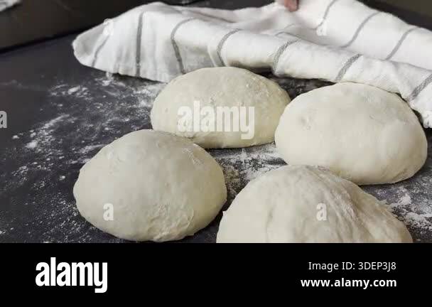 Female hand checking fresh yeast dough on floured table covered with ...
