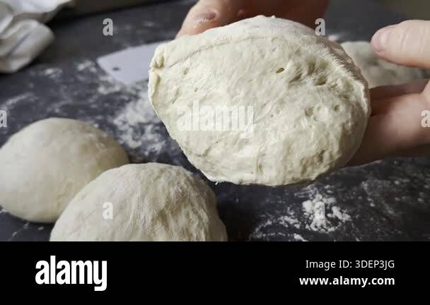Female hands cutting and forming balls of fresh yeast dough on floured ...