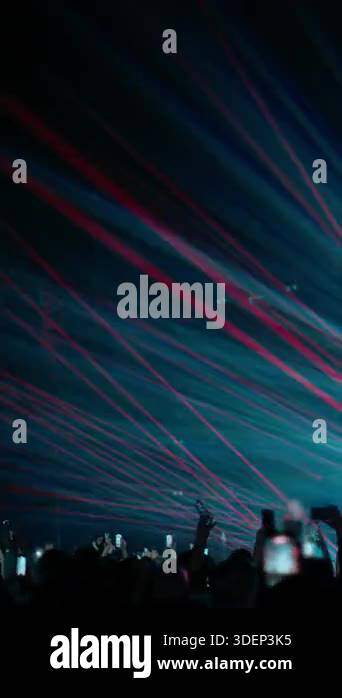 Packed concert crowd lit by sharp laser beams and stage effects Stock ...