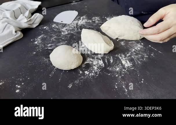 Female hands cutting and forming balls of fresh yeast dough on floured ...