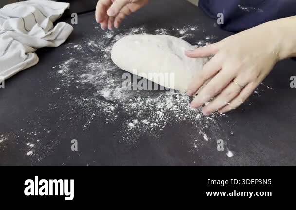Female hands cutting fresh yeast dough into smaller pieces on floured ...