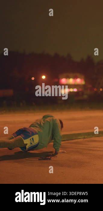 White man collapsed on asphalt, night streetlights glow, skateboard ...
