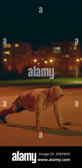 Focused athlete pushes on dark street, Determined sports enthusiast ...