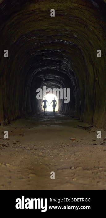 Vertical video. Man and Woman Walk Together from Bright Tunnel Entrance ...