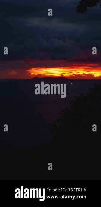 Vertical video. Woman Approaches Cliffside Alone to Watch Fiery Sunset ...