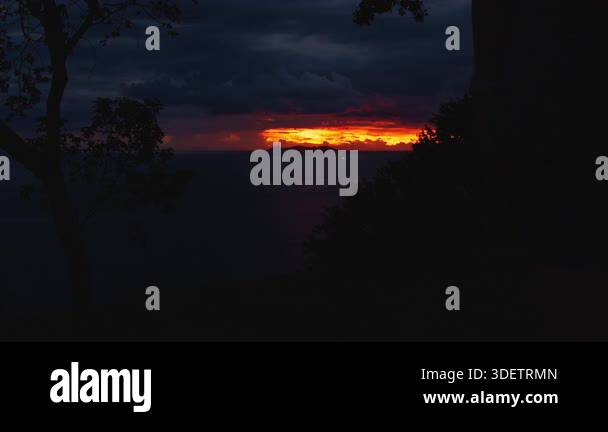Woman Approaches Cliffside Alone to Watch Fiery Sunset Over the Ocean ...