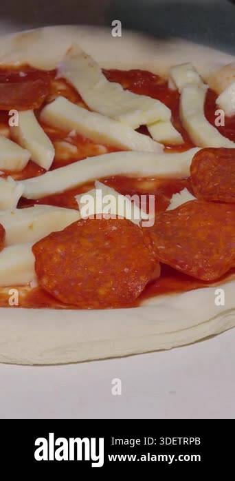 Vertical video Chefs Gloved Hands Placing Pepperoni Slices onto Pizza ...