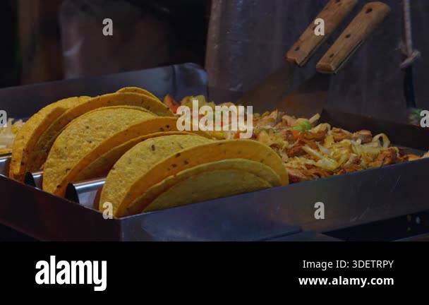 Row of Hard-Shell Tacos Standing Upright beside Cooked Chicken and ...