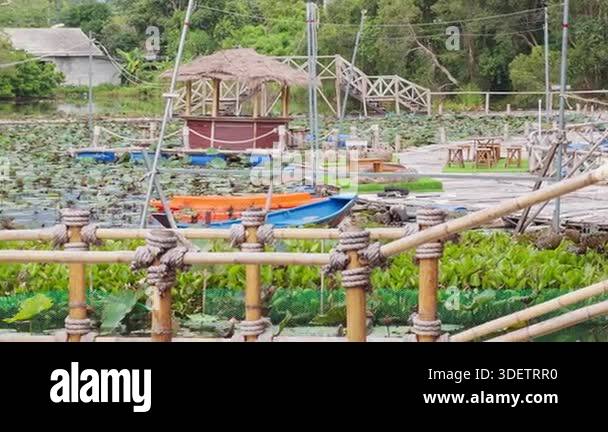 Tropical Garden with Wooden Bridges, Boats, and Thatched Huts around ...