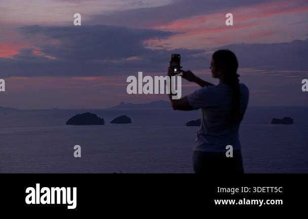 Woman Taking Picture of Distant Islands during Sunset with Smartphone ...