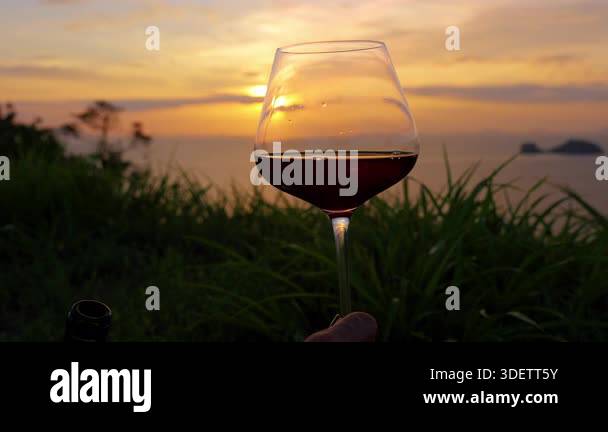 Hand Holding Glass of Red Wine Facing Ocean Horizon at Sunset, Close Up ...