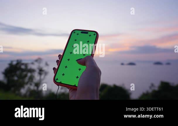 Female Hand Holding Smartphone with Green Screen over Ocean Horizon at ...