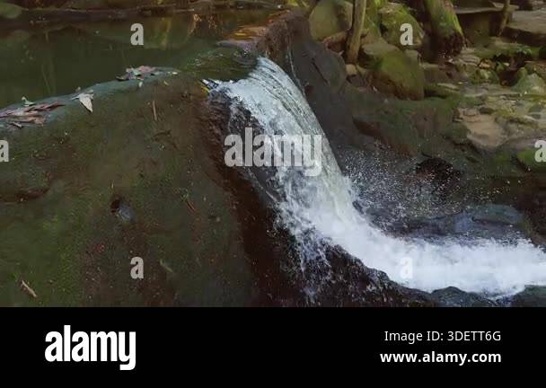 Close Up of Waterfall Pouring over Mossy Rocks in Tropical Forest, Slow ...