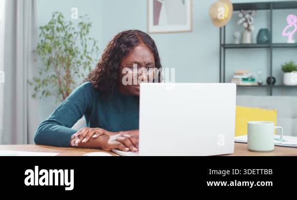 Unhappy African American beautiful girl worker looking at laptop while ...
