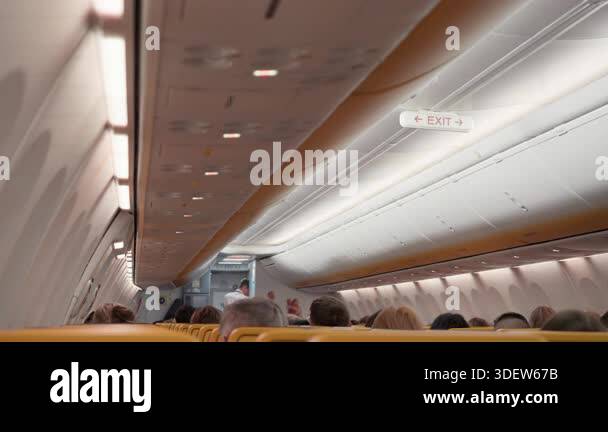 Illuminated Exit sign visible on the ceiling panel of a commercial ...