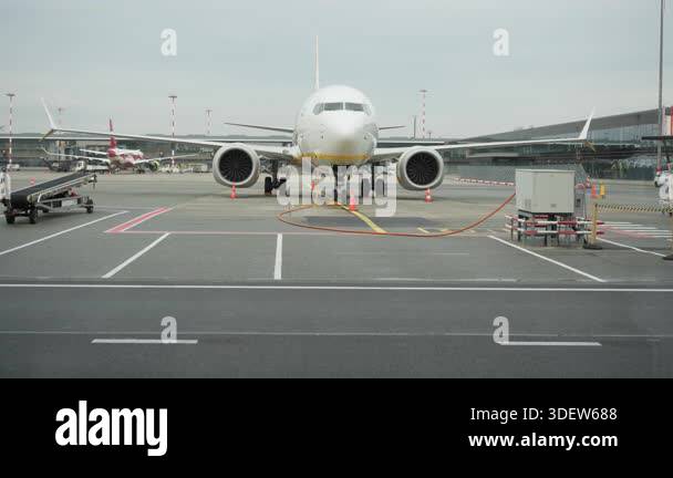 Front view of commercial airplane parked at airport apron connected to ...