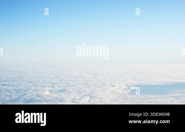 High altitude aerial view tilting down from clear blue sky to dense ...