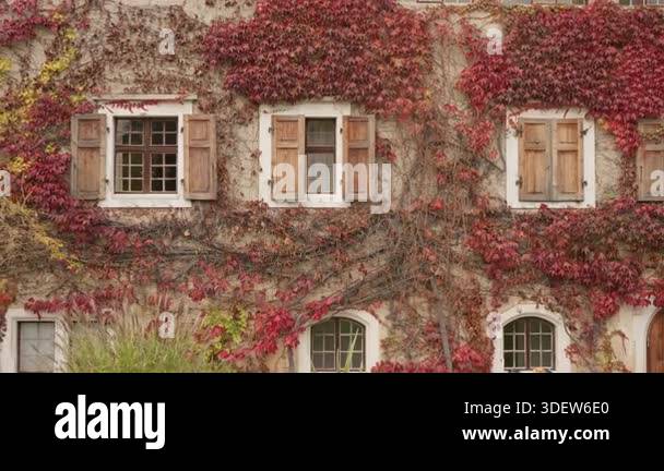 Wooden shuttered windows adorn stone facade of historic building ...