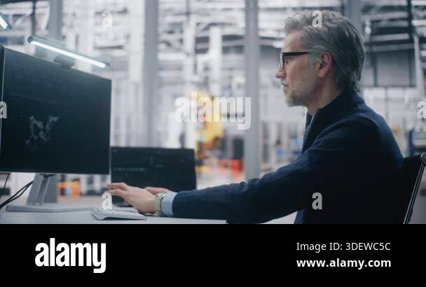 Senior Engineer Typing Dual Screen Workstation, Monitoring 3D Robotic ...