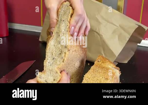 Baker breaking hot and fresh bread. Male baker hands breaking homemade ...