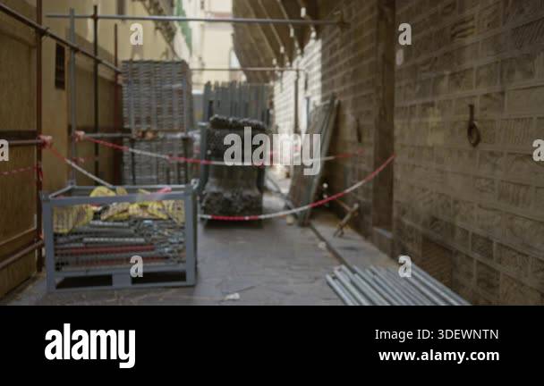 Defocused construction alley with stacked scaffolding, crate and metal ...