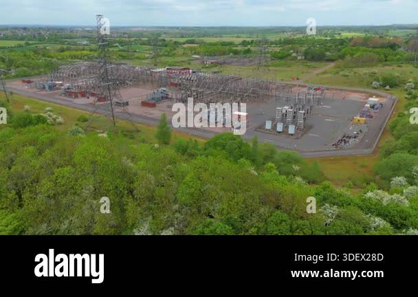 Aerial drone shot of electrical substation with powerlines pylons and ...
