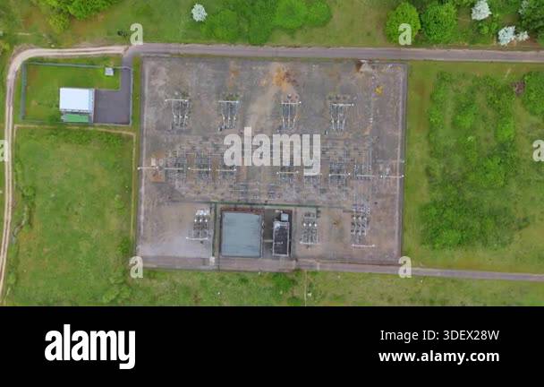 Aerial drone shot of electrical substation with powerlines pylons and ...