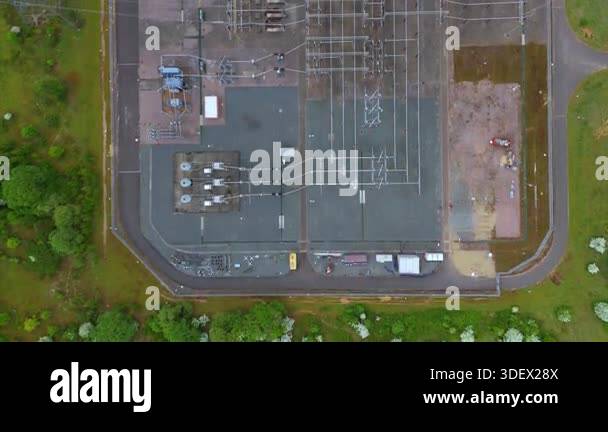 Aerial drone shot of electrical substation with powerlines pylons and ...